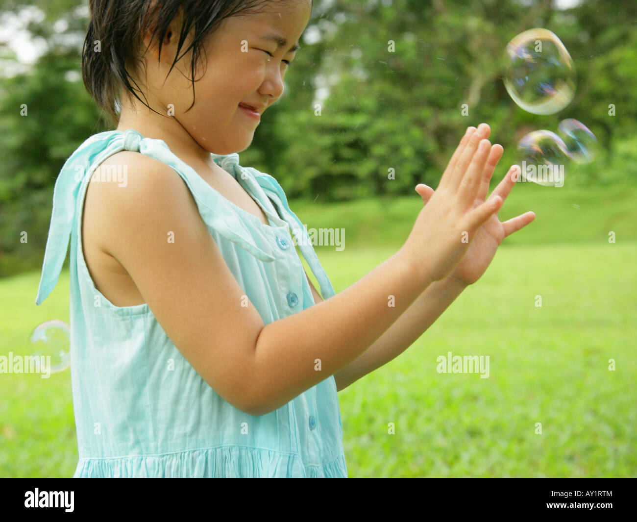 Close-up of a girl catching bubbles Stock Photo - Alamy