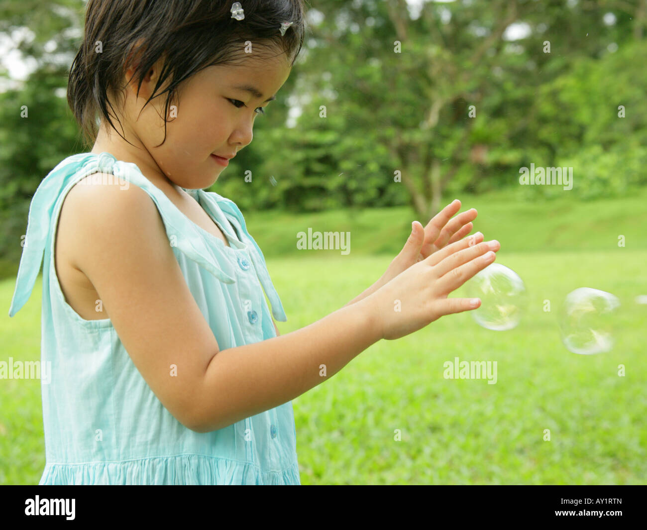 Close-up of a girl catching bubbles Stock Photo - Alamy