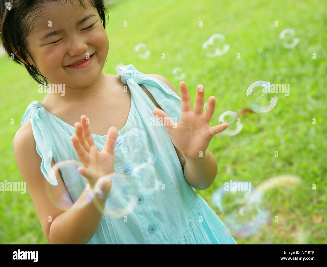 Close-up of a girl catching bubbles Stock Photo - Alamy