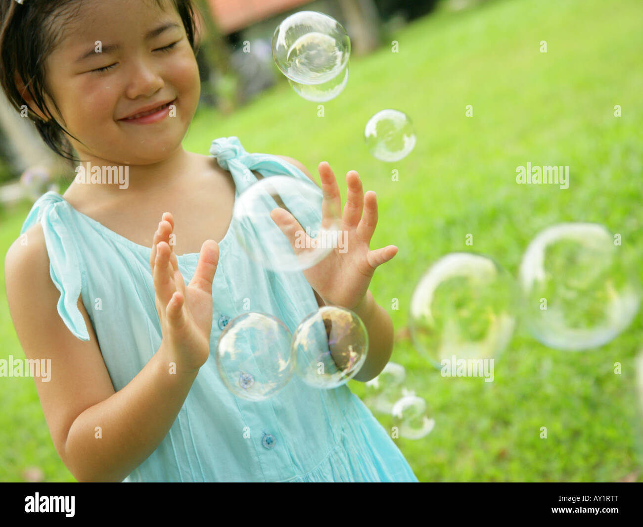 Close-up of a girl catching bubbles Stock Photo - Alamy