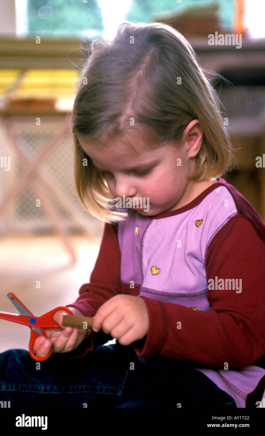 Girl cutting paper with scissors Stock Photo - Alamy