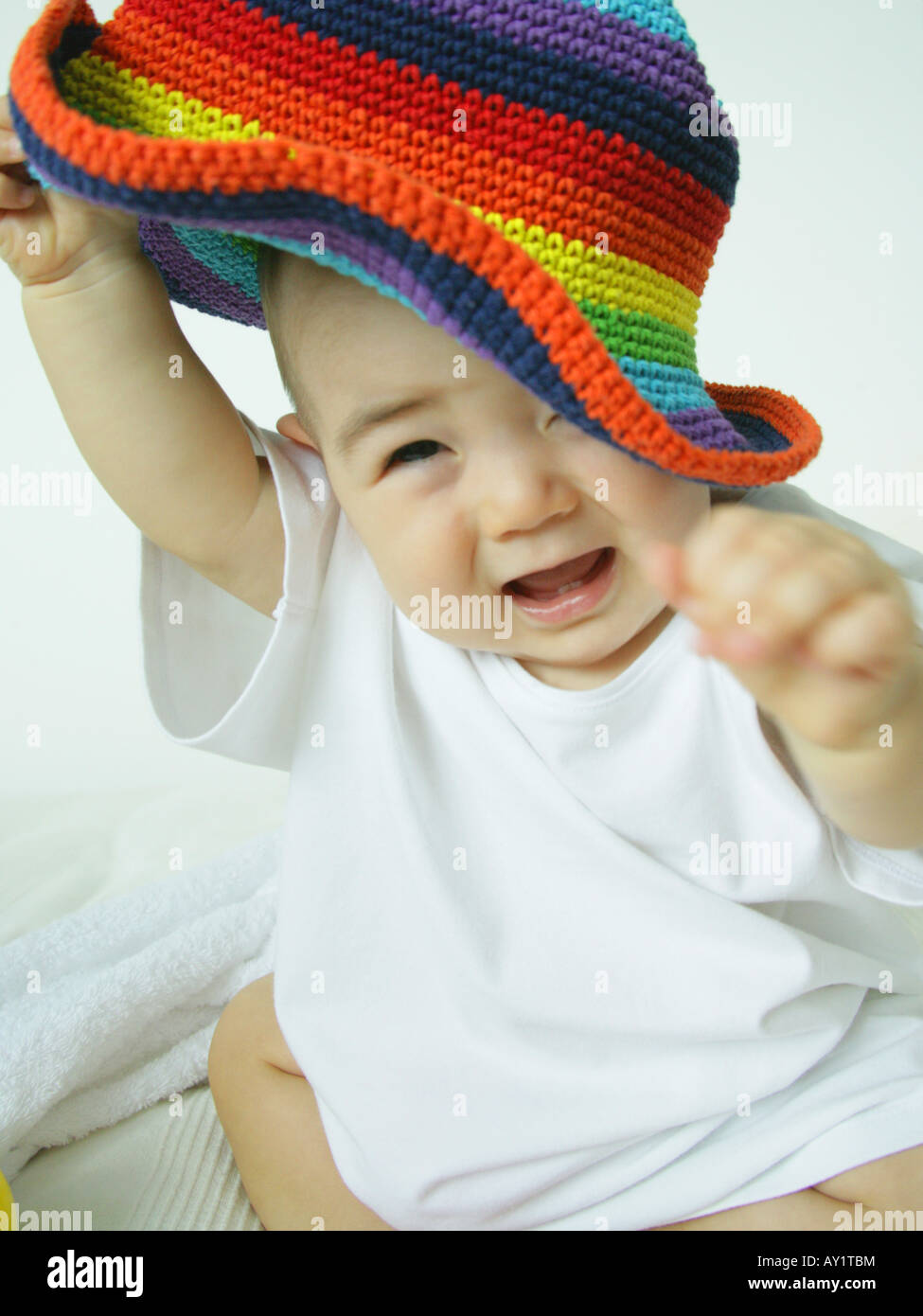 Close-up of a baby girl pulling her hat Stock Photo - Alamy