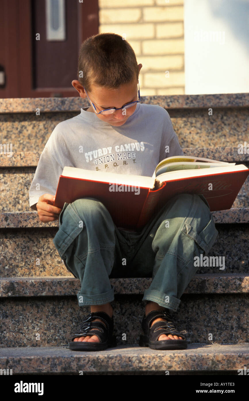 Boy reading a book Stock Photo - Alamy