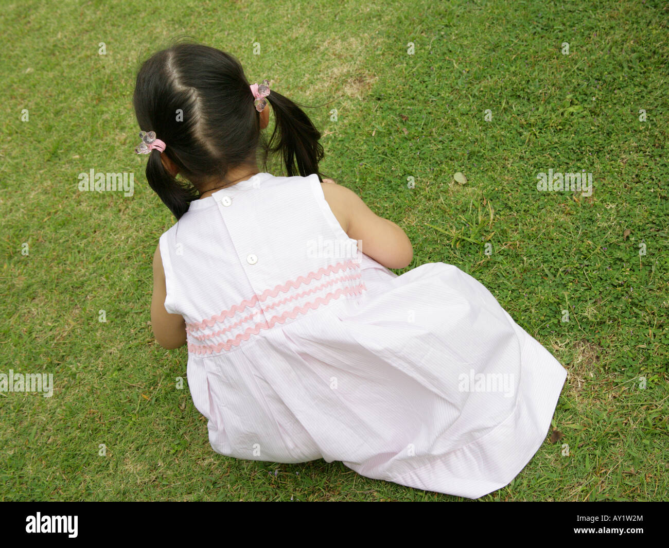 High angle view of a girl crouching on the lawn Stock Photo - Alamy