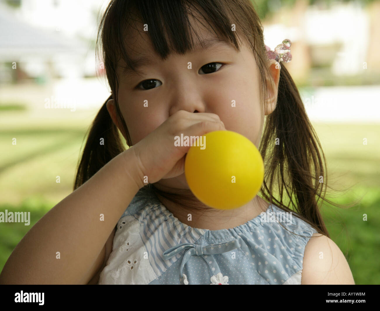 Girl blowing up balloon outdoors hi-res stock photography and images ...
