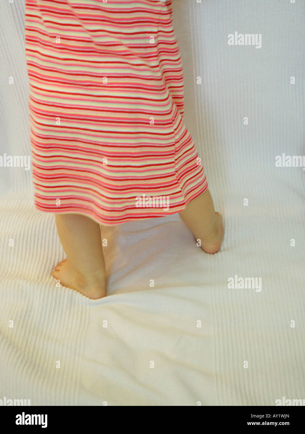 Low section view of a baby standing on a sheet Stock Photo - Alamy