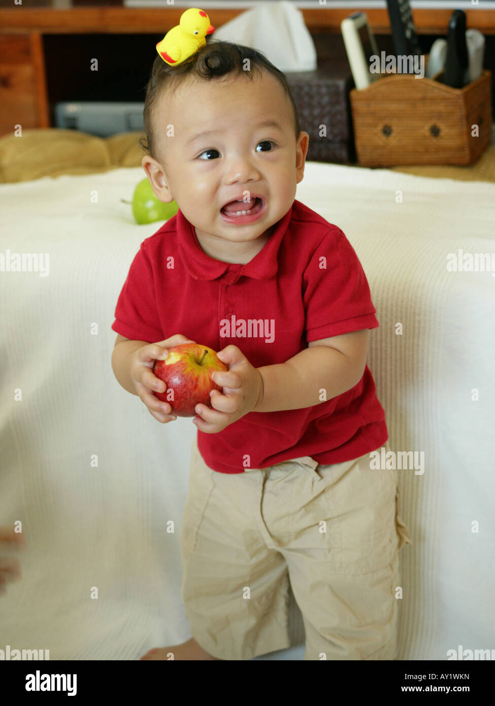 Close-up of a baby boy holding an apple crying Stock Photo - Alamy