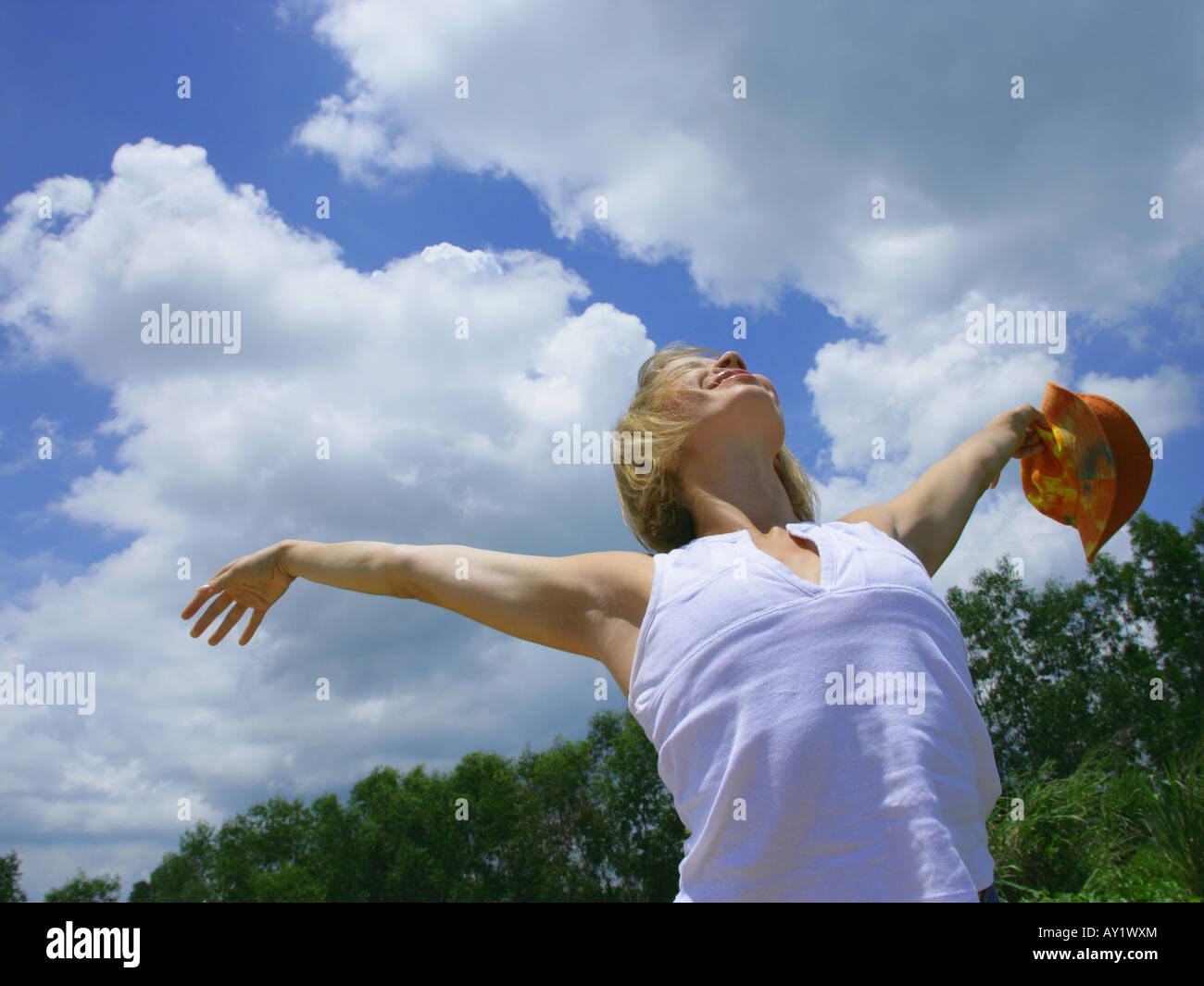Low angle view of a young woman standing with her arms outstretched ...