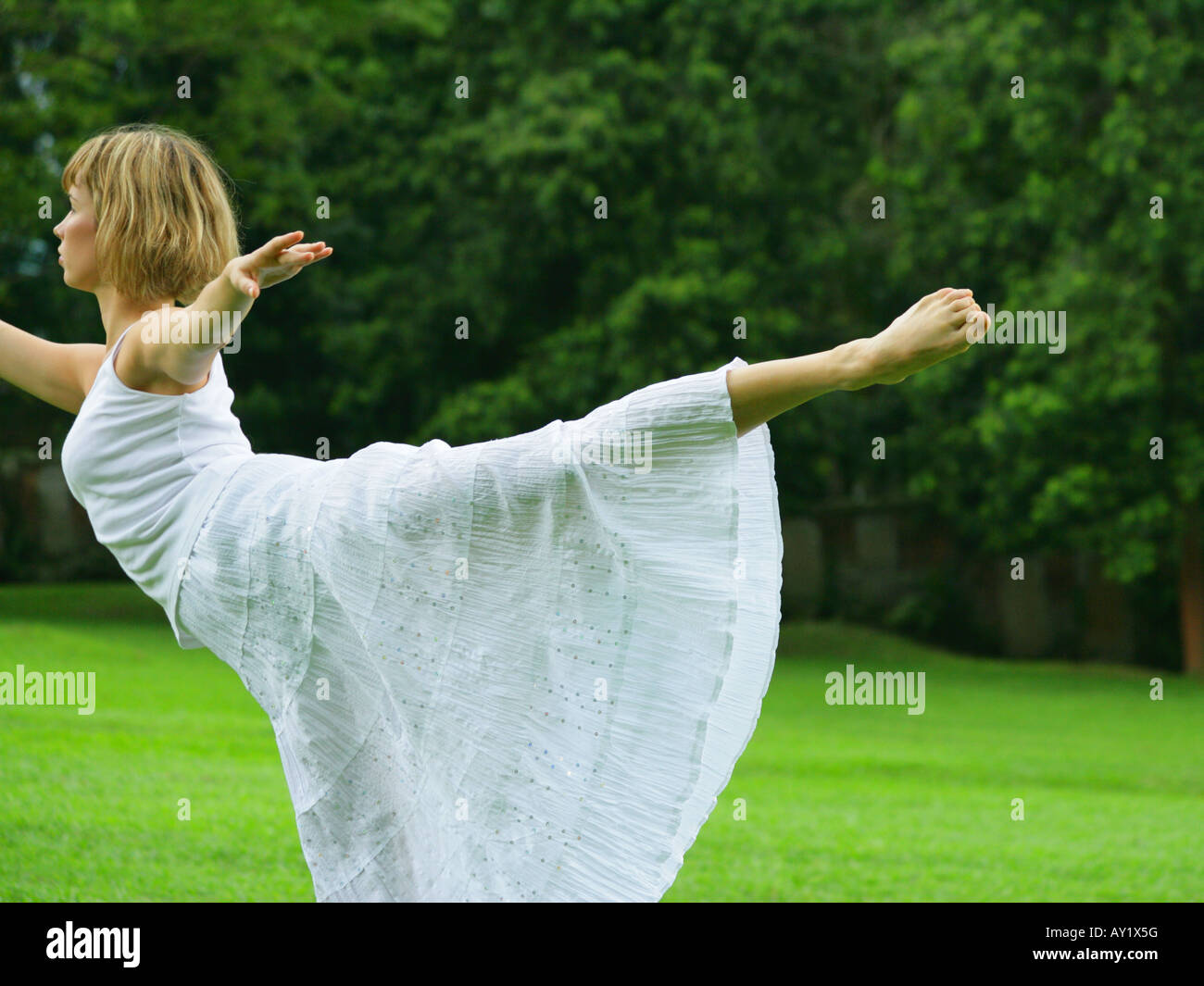 Side profile of a young woman dancing on the lawn Stock Photo - Alamy