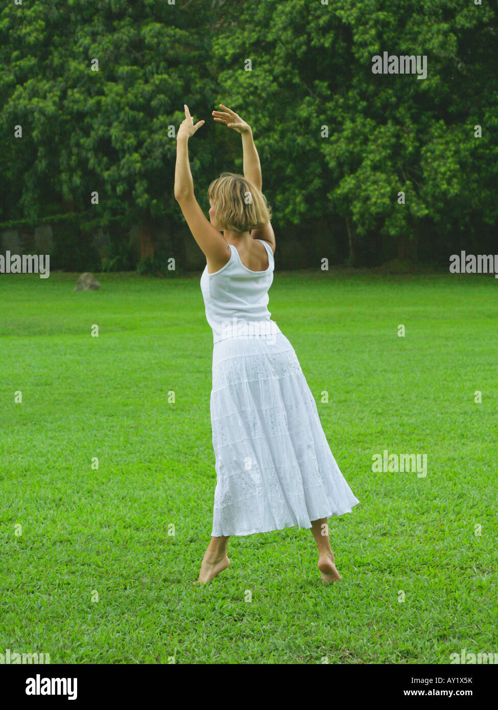 Side profile of a young woman dancing on the lawn Stock Photo - Alamy