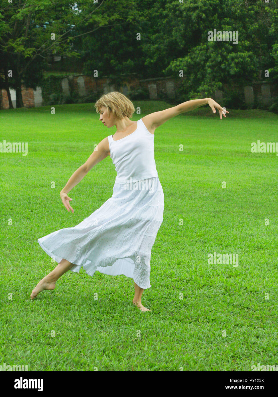 Young woman dancing on the lawn Stock Photo - Alamy