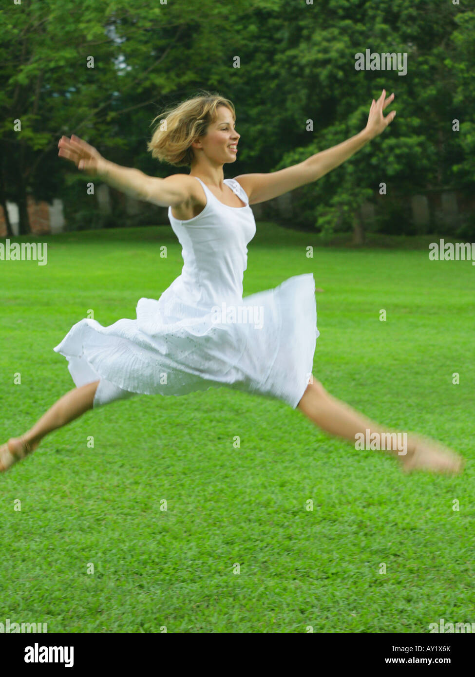 Side profile of a young woman dancing on the lawn Stock Photo - Alamy