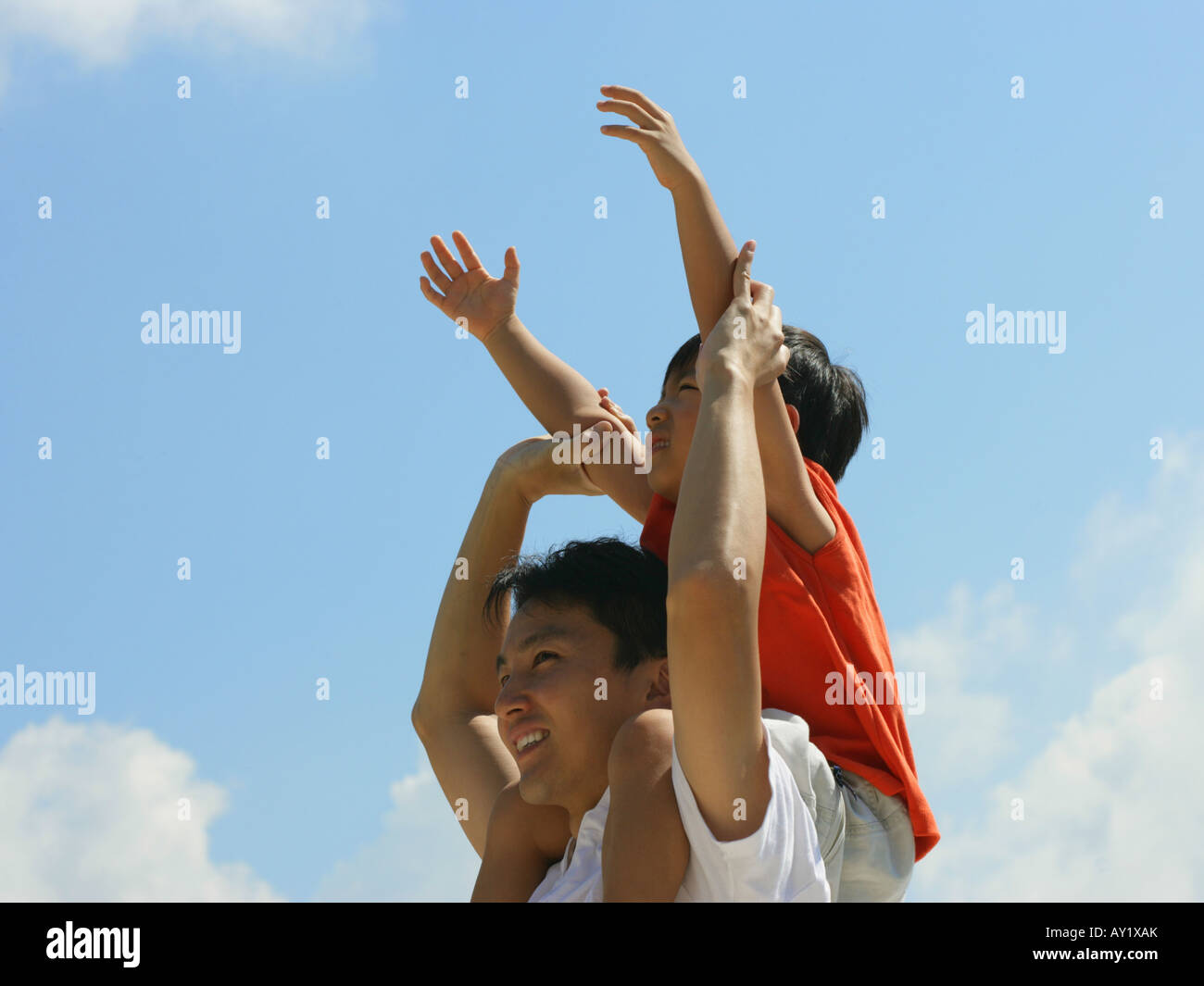 Side profile of a father carrying his son on his shoulders Stock Photo ...