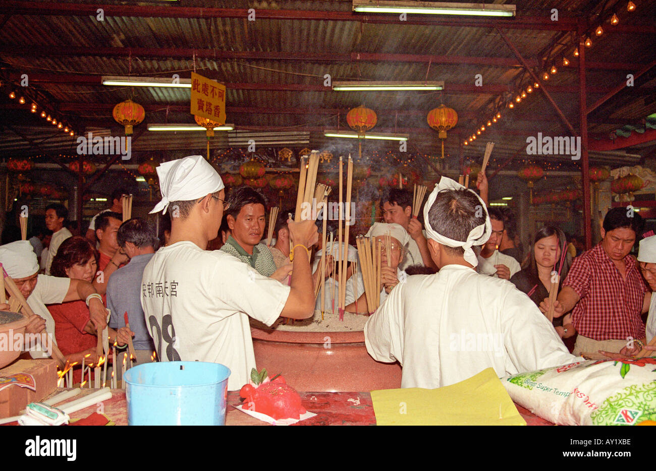 Temple helpers trying to clear the josticks at an urn during the Nine ...