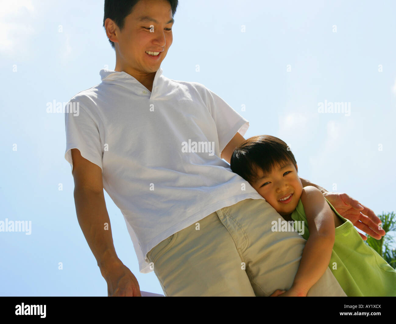 Portrait of a boy hugging his father's leg Stock Photo - Alamy