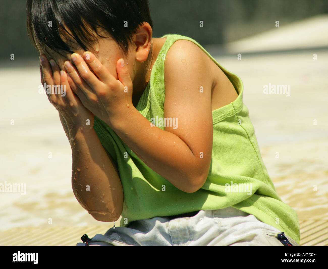 Close-up of a boy covering his face Stock Photo - Alamy