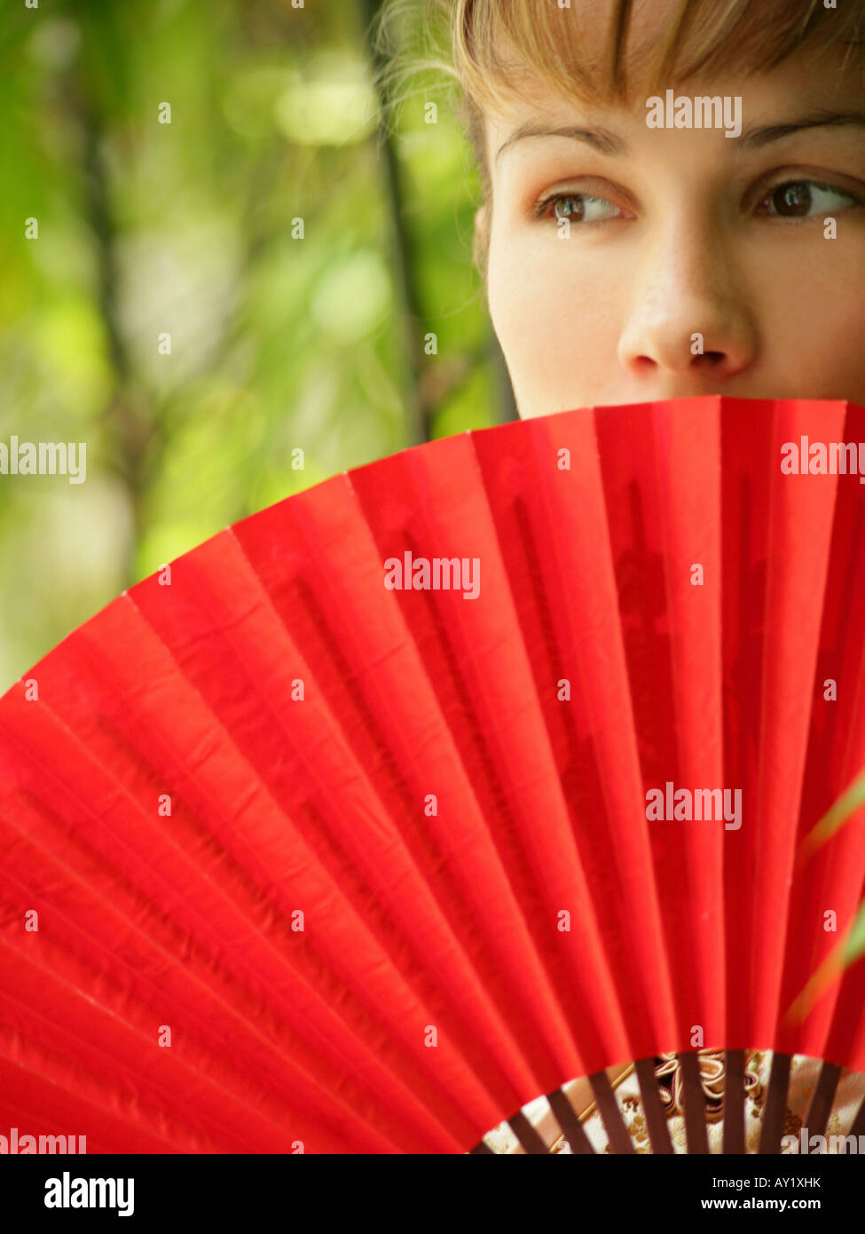 Close-up of a young woman with a folding fan in front of her face Stock ...
