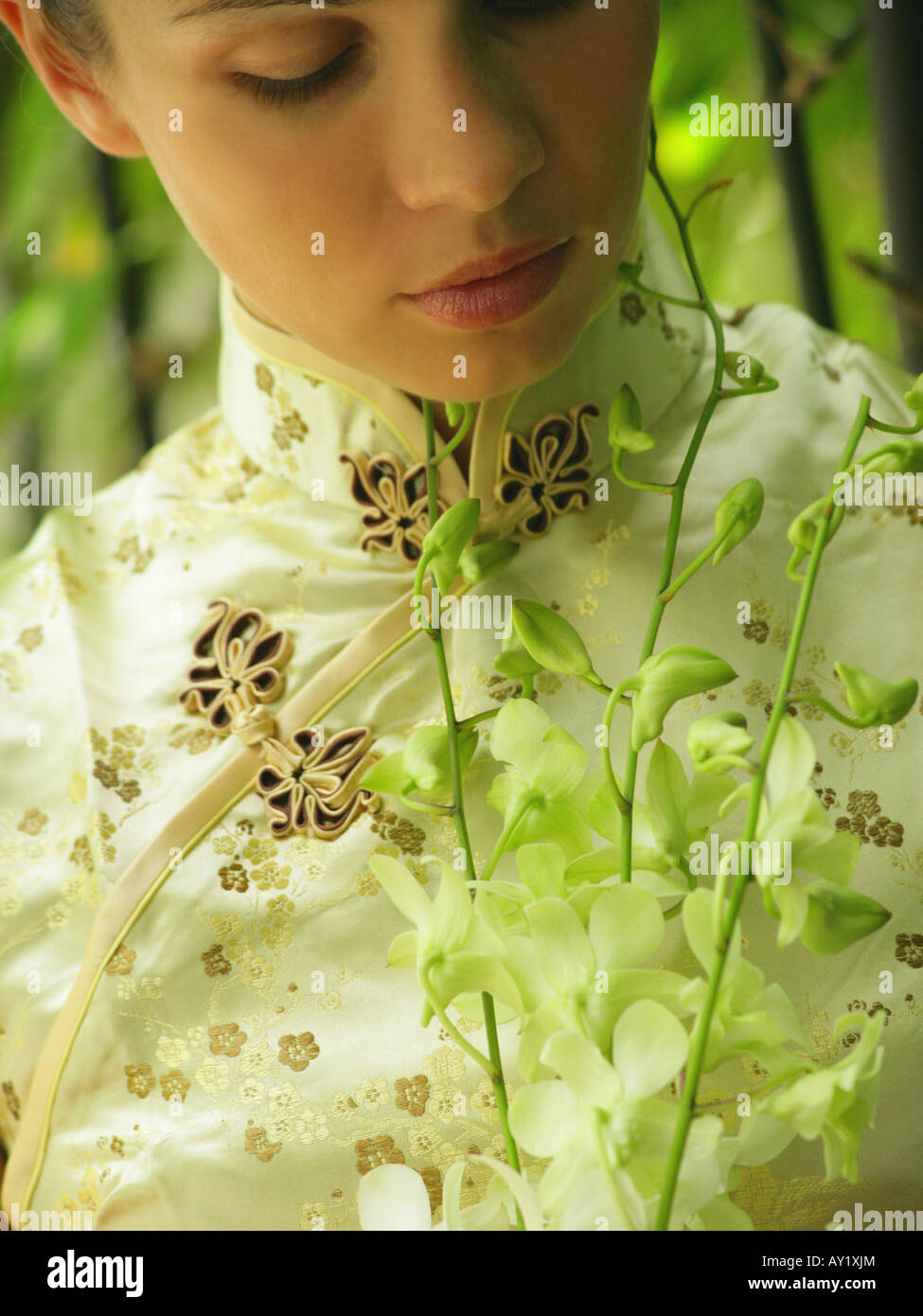 Close-up of a young woman looking at flowers (Orchid Stock Photo - Alamy