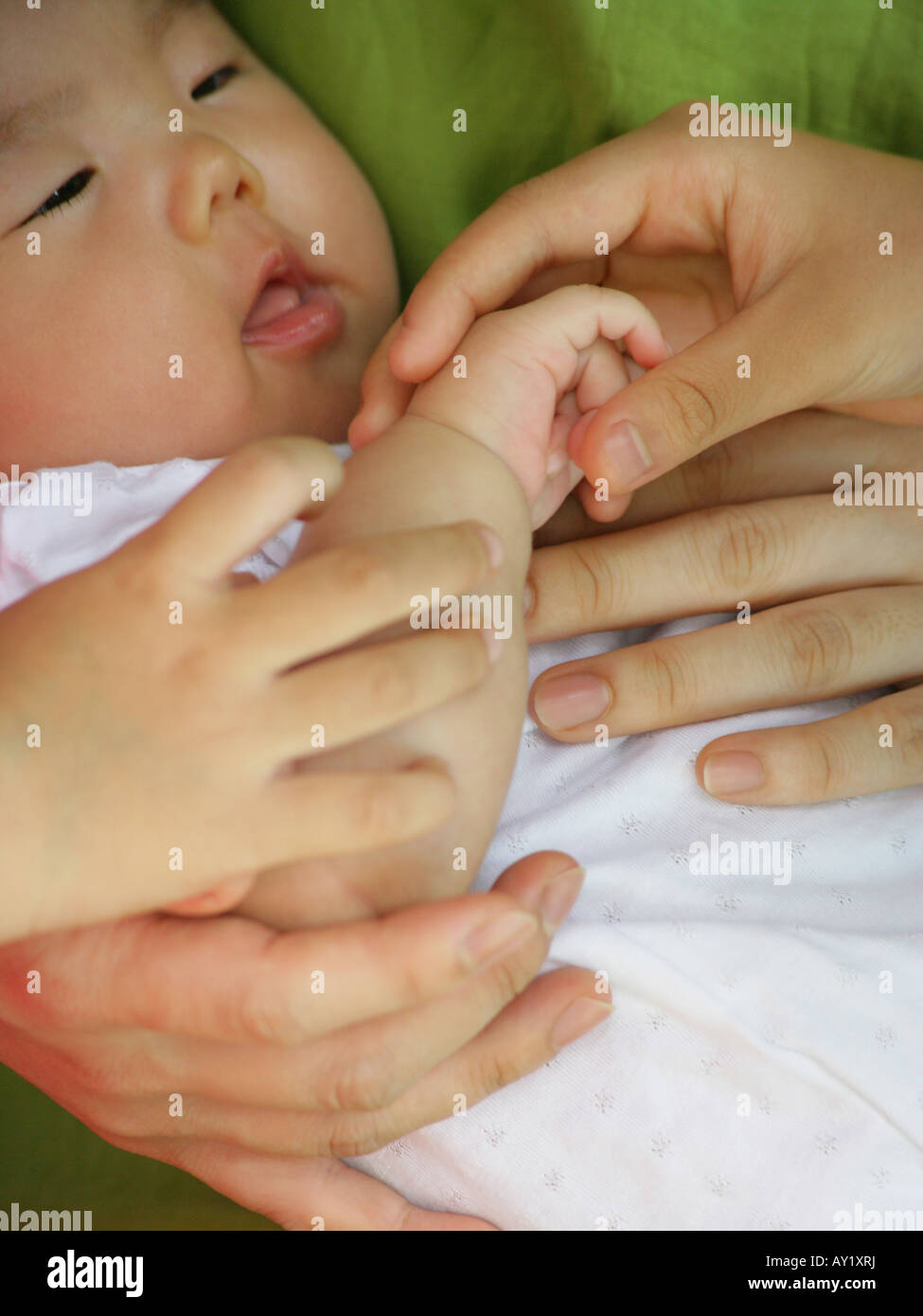 Three people's hands touching a baby Stock Photo - Alamy