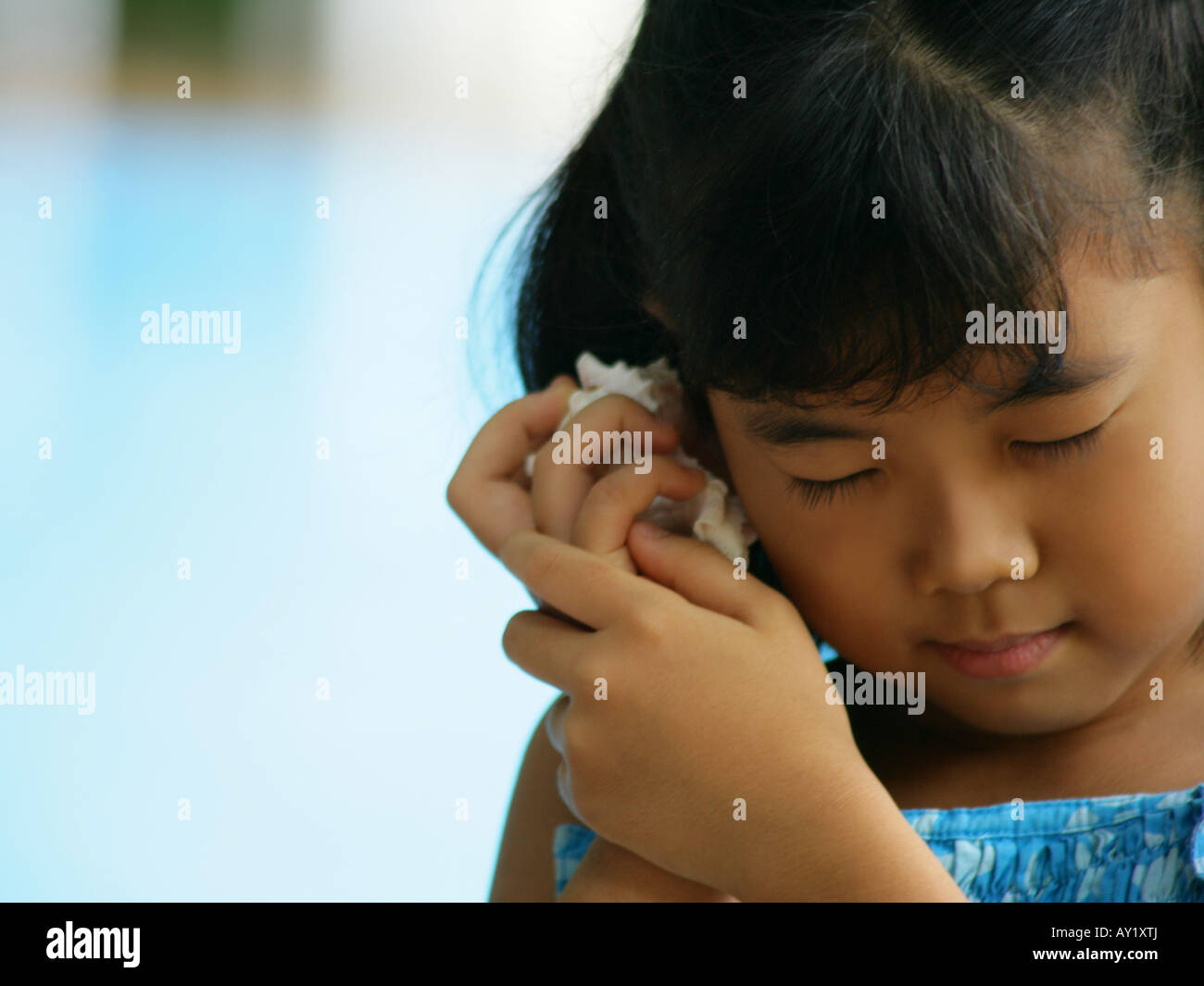 Girl holding shell to ear hi-res stock photography and images - Alamy