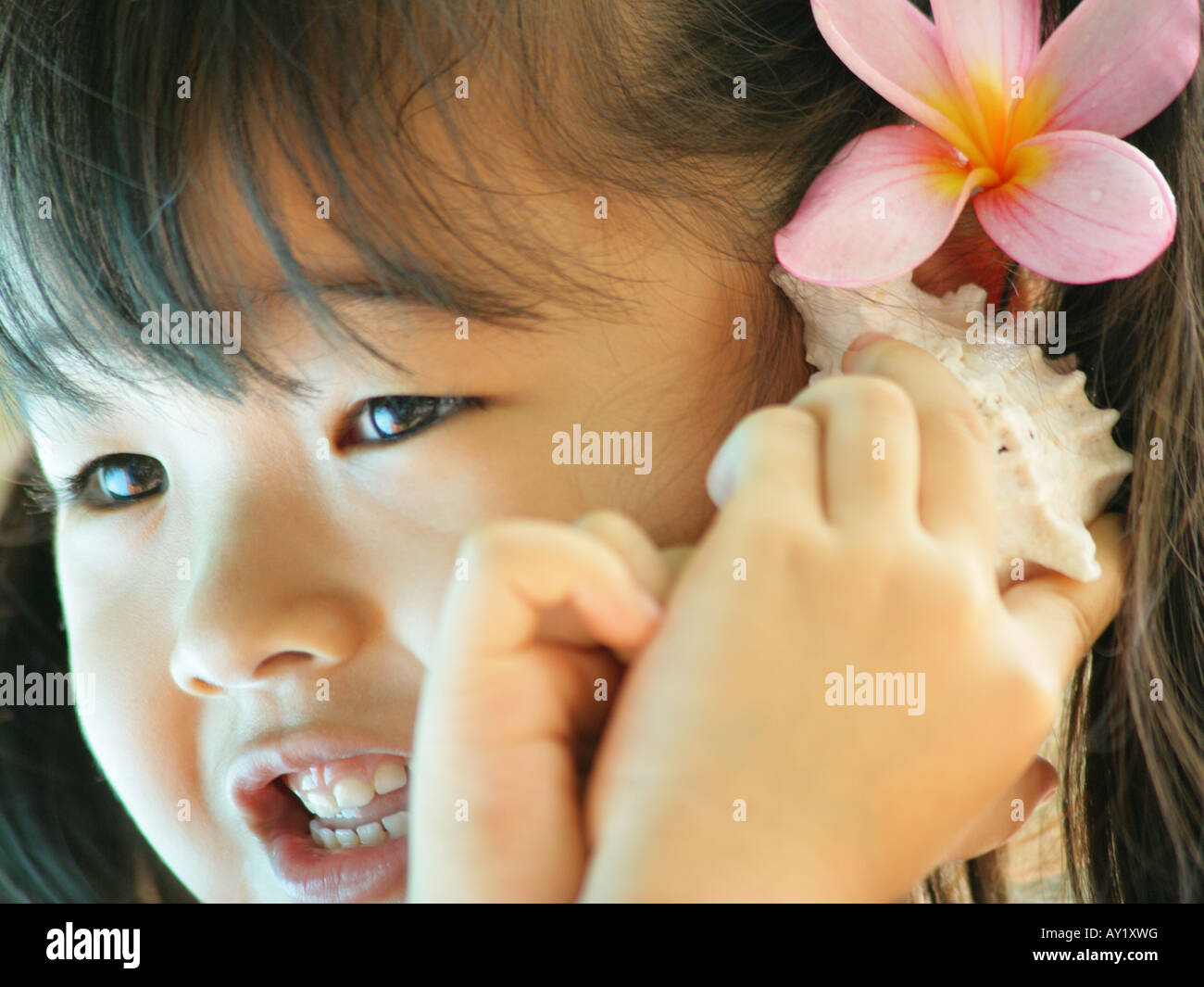 Girl holding shell to ear hi-res stock photography and images - Alamy