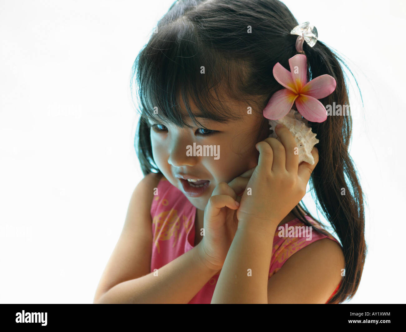 Girl holding shell to ear hi-res stock photography and images - Alamy