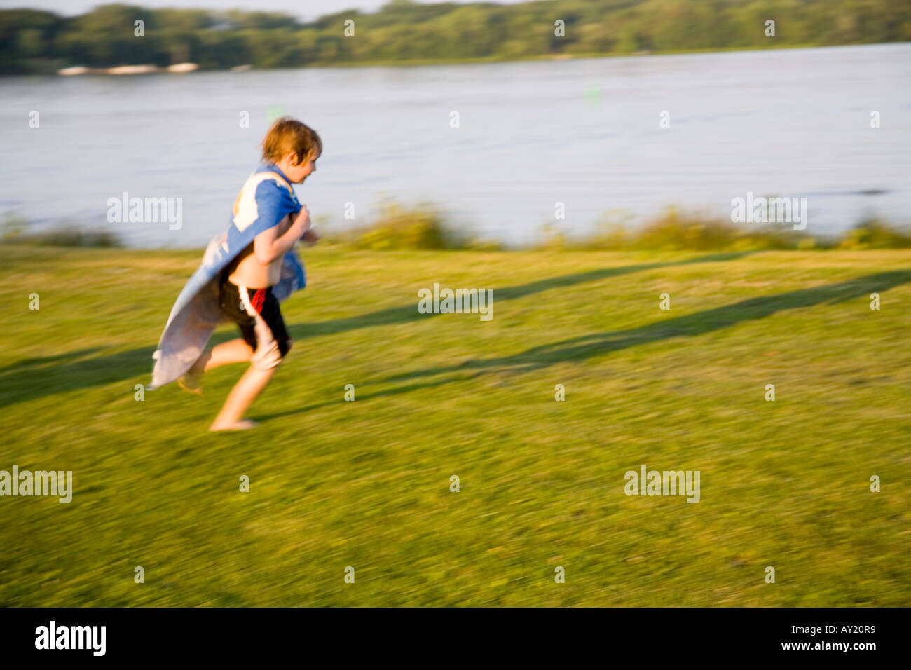 Boy running with towel cape Stock Photo - Alamy