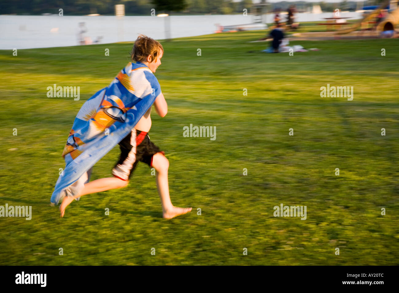 Boy running with towel cape Stock Photo - Alamy
