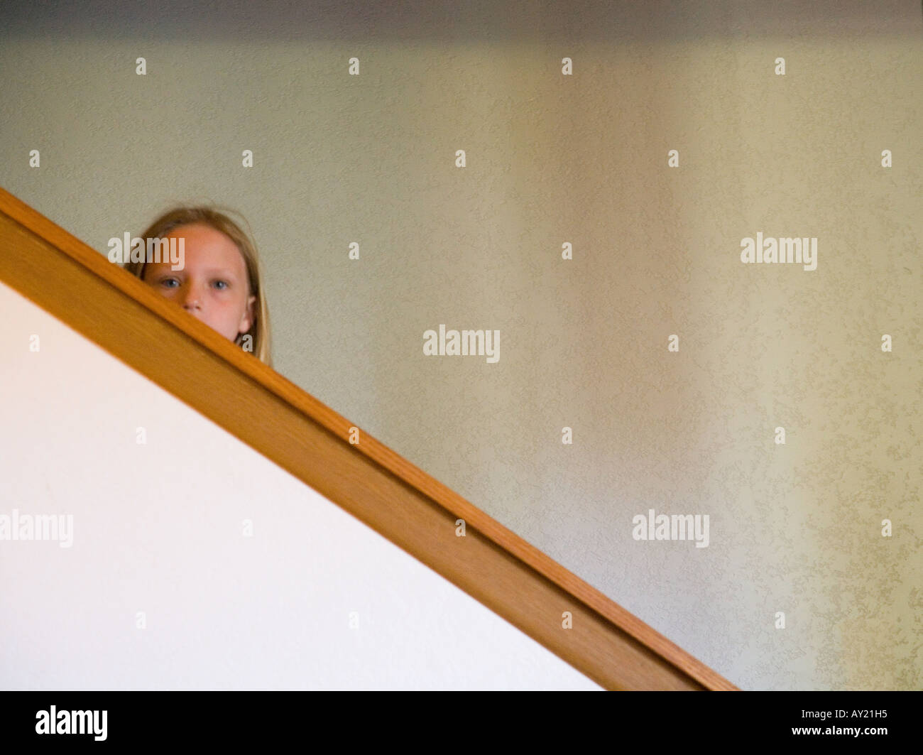 Young girl spying from stairs Stock Photo - Alamy