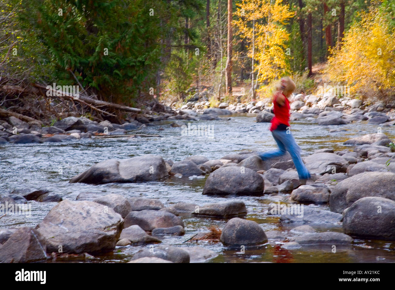Young girl, boulder hopping in river Stock Photo - Alamy