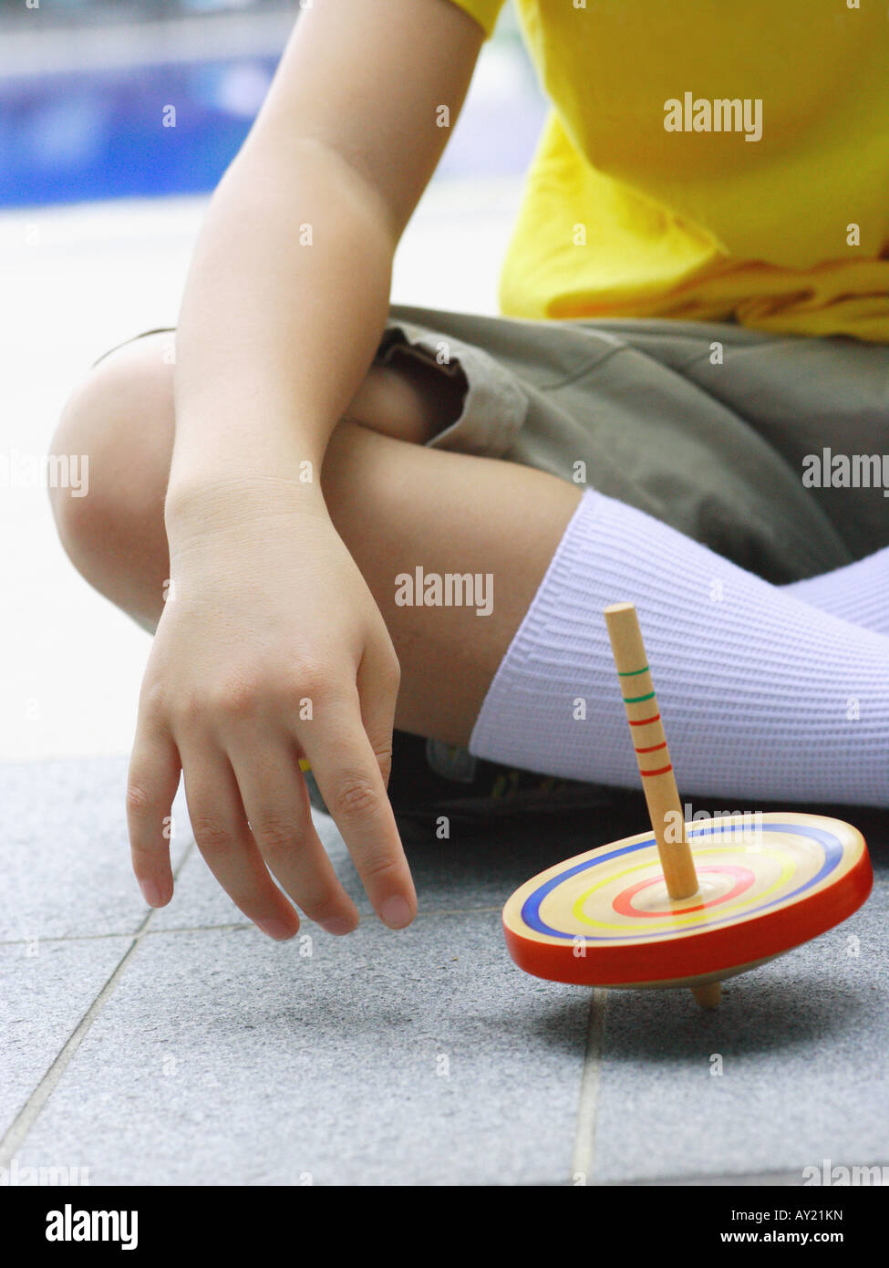 Mid section view of a boy playing with a top Stock Photo - Alamy