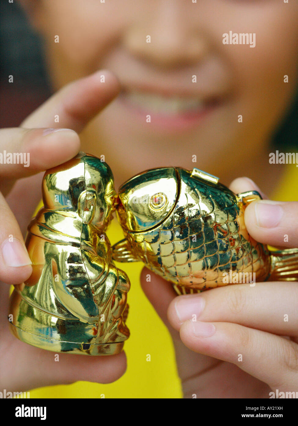 Close-up of a girl holding two pieces of a good luck charm and smiling ...