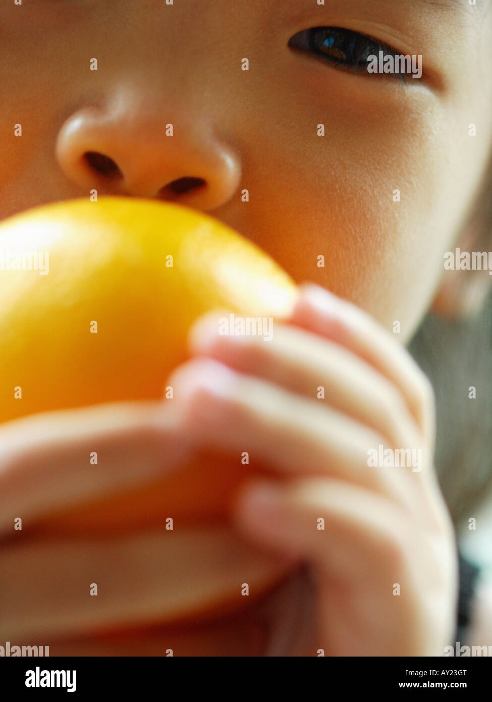 Close-up of a girl biting an orange Stock Photo - Alamy