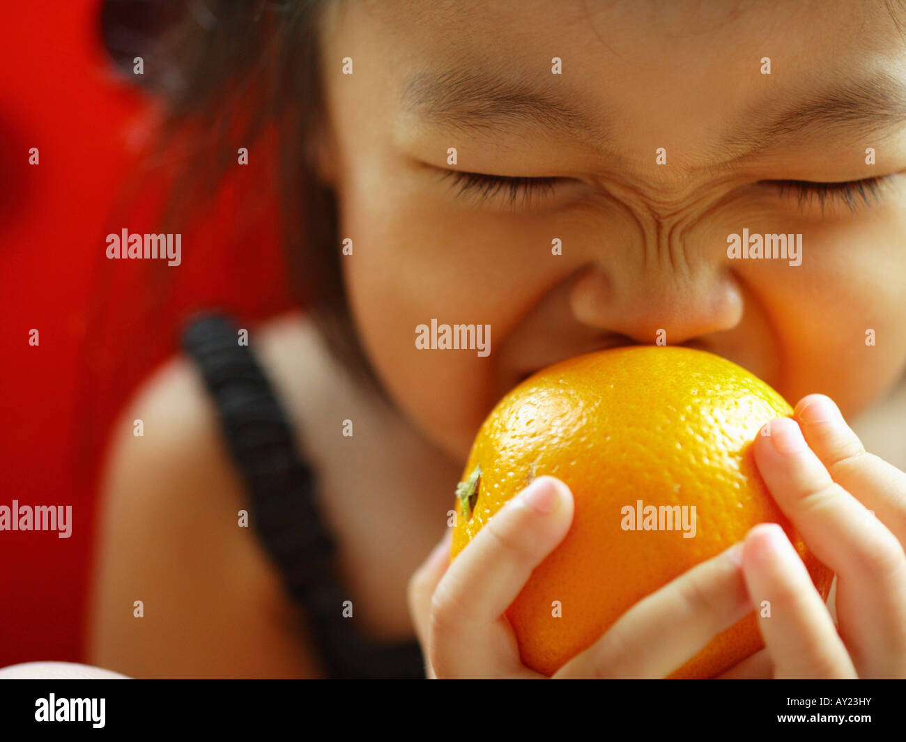 Close-up of a girl biting an orange Stock Photo - Alamy