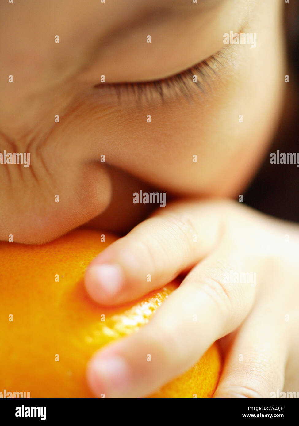 Close-up of a girl biting an orange Stock Photo - Alamy