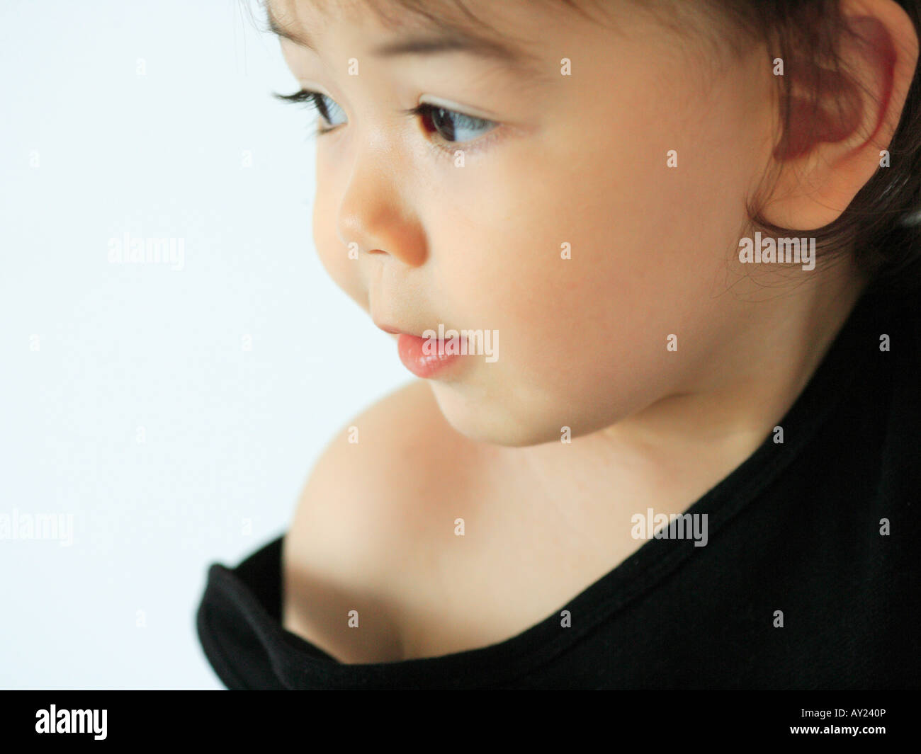 Close-up of a baby girl looking sideways Stock Photo - Alamy
