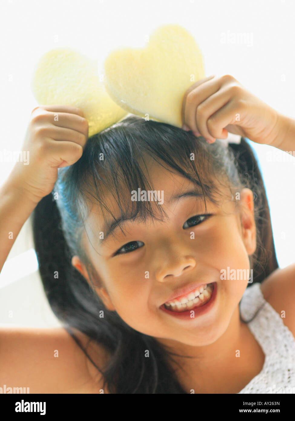Portrait of a girl holding two heart shaped breads over her head Stock ...