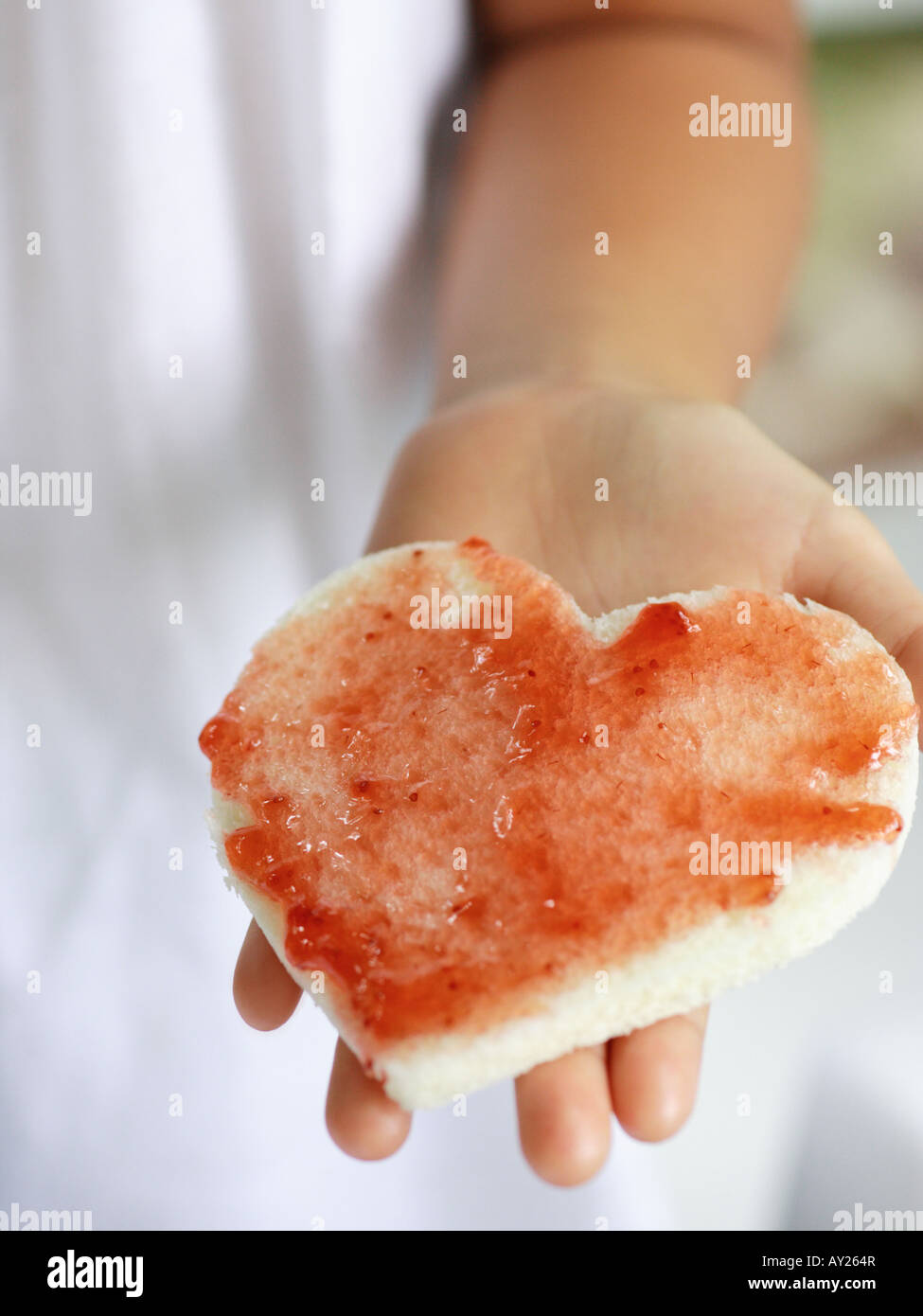 Close-up of a girl's hand holding a heart shaped bread Stock Photo - Alamy