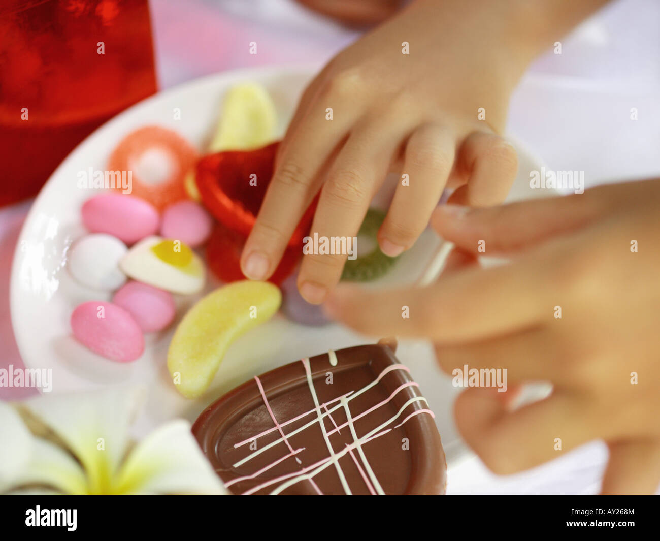 Close-up of a child's hand taking candy from a plate Stock Photo - Alamy