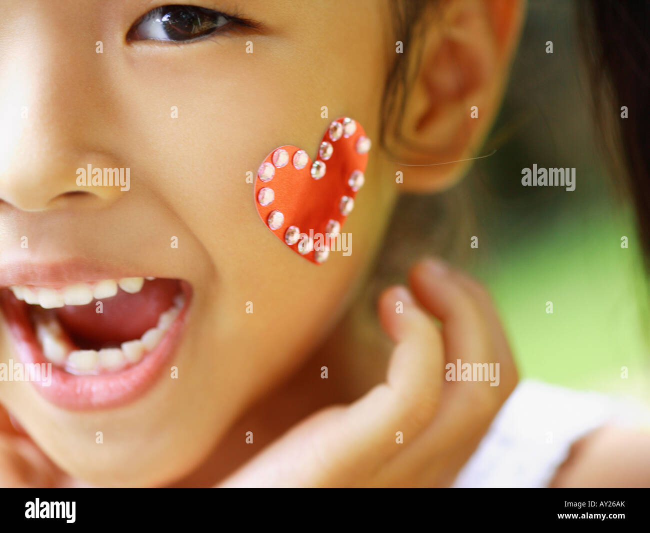 Portrait of a girl with a heart shape stuck on her cheek Stock Photo ...
