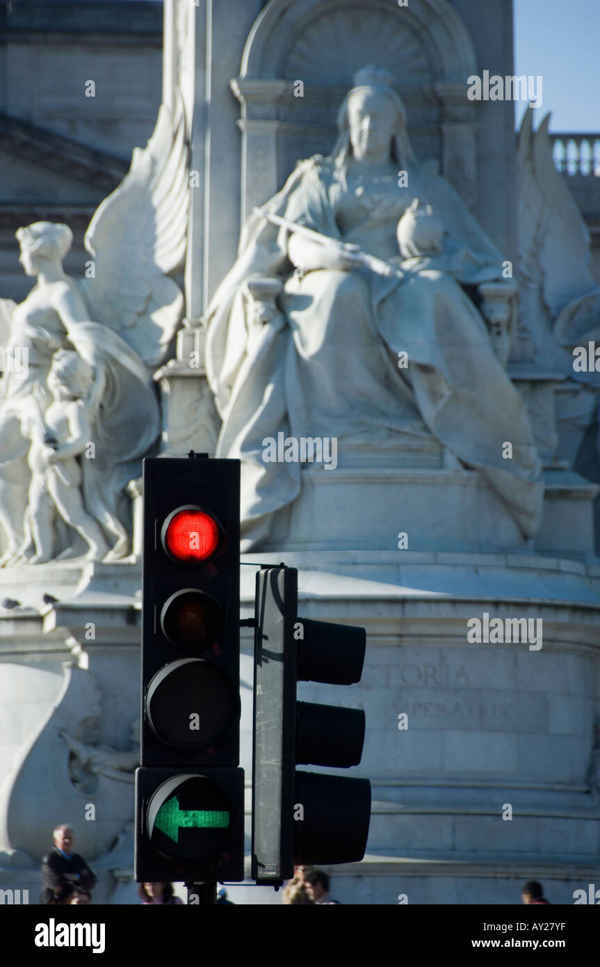 Traffic lights with red light and green arrow watched by the statue of ...
