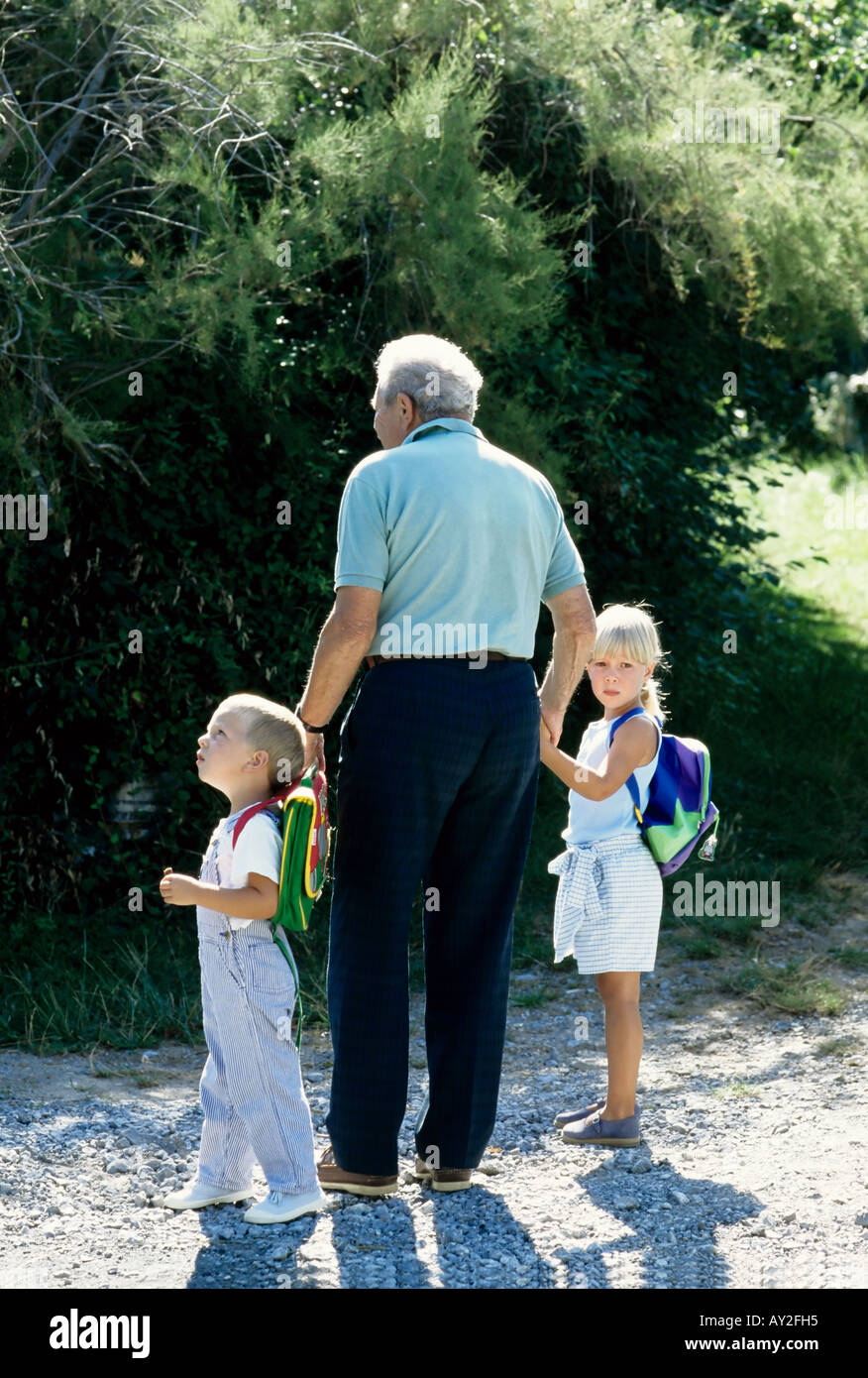 MR GRANDFATHER WALKING LITTLE BOY AND GIRL TO SCHOOL Stock Photo - Alamy