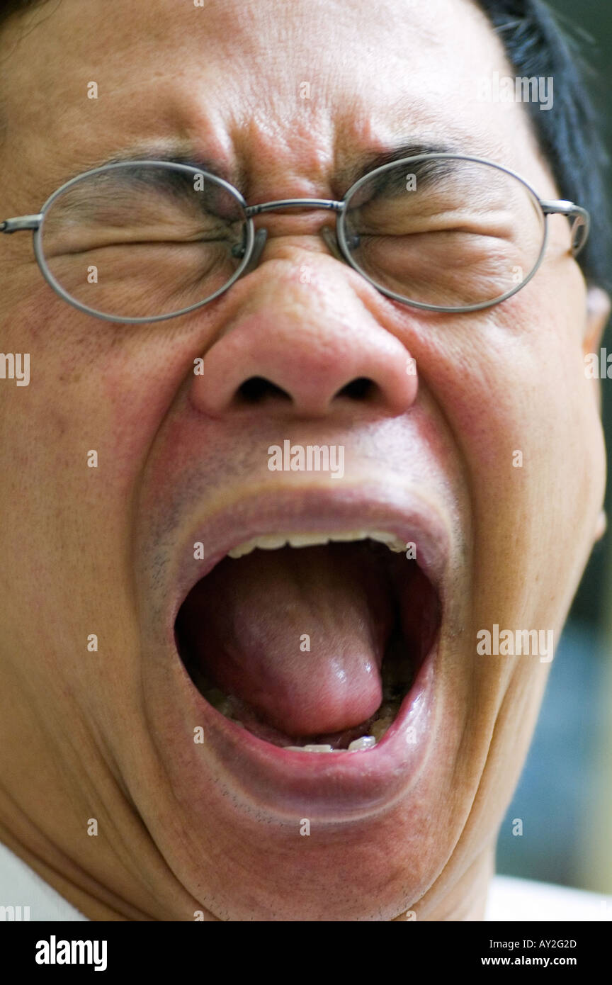 Portrait of an Asian man yawning Stock Photo - Alamy