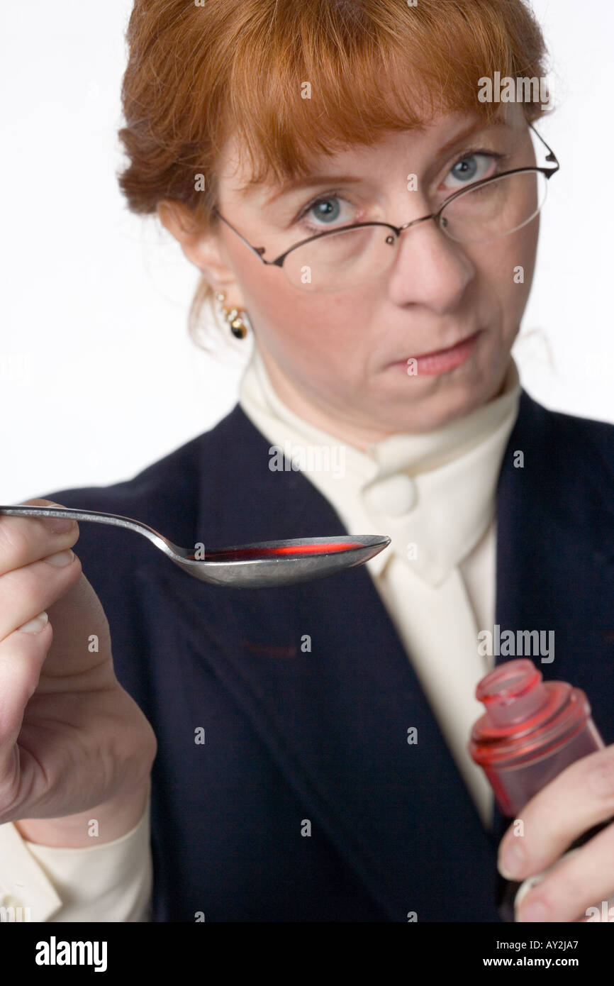 A very stern mother offering a spoonful of bad tasting medicine Stock ...