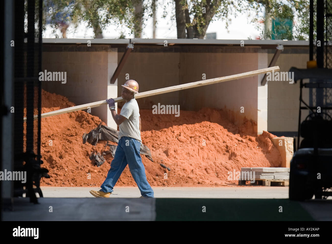 Worker carrying a beam Stock Photo - Alamy