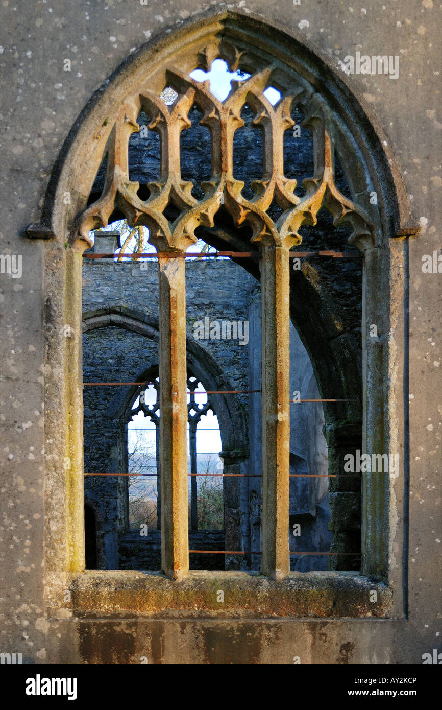 View through a glassless arched window of a derelict church burnt out ...