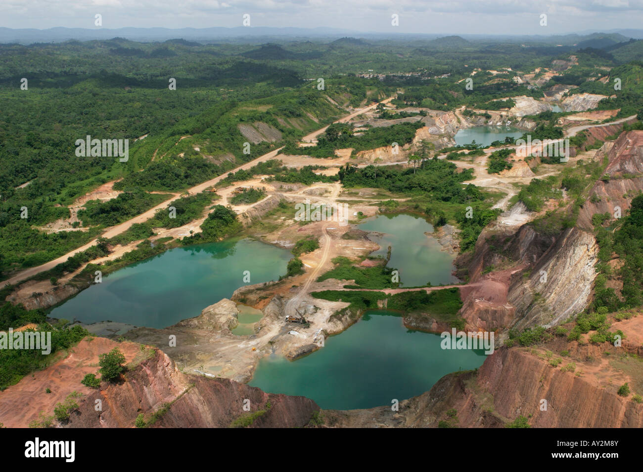 Aerial view looking along African gold mining concession with old pits ...