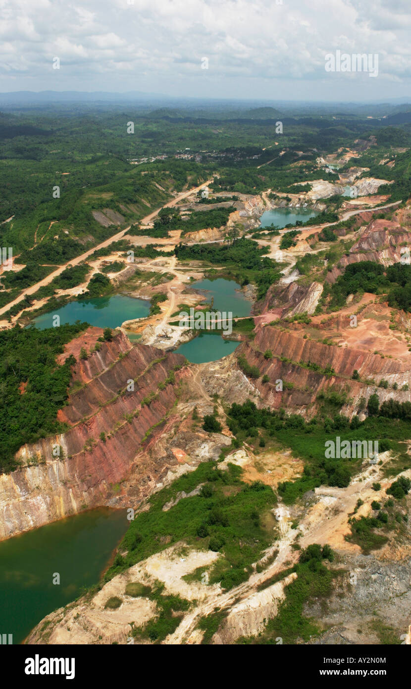 Aerial view looking along African gold mining concession with old pits ...