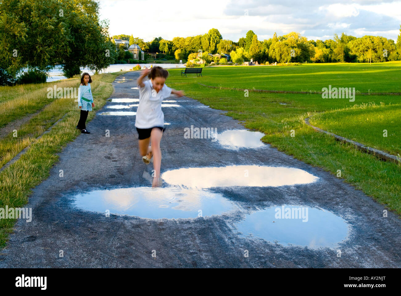 child girl jumping over puddle Stock Photo - Alamy