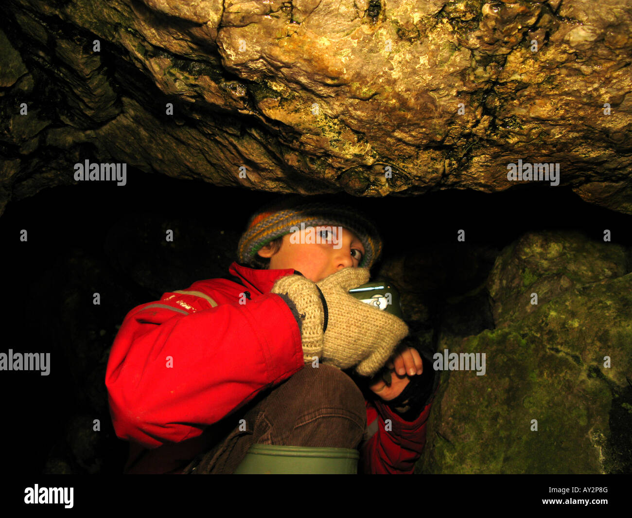 A child exploring a cave in Winnats Pass Castleton Peak District ...